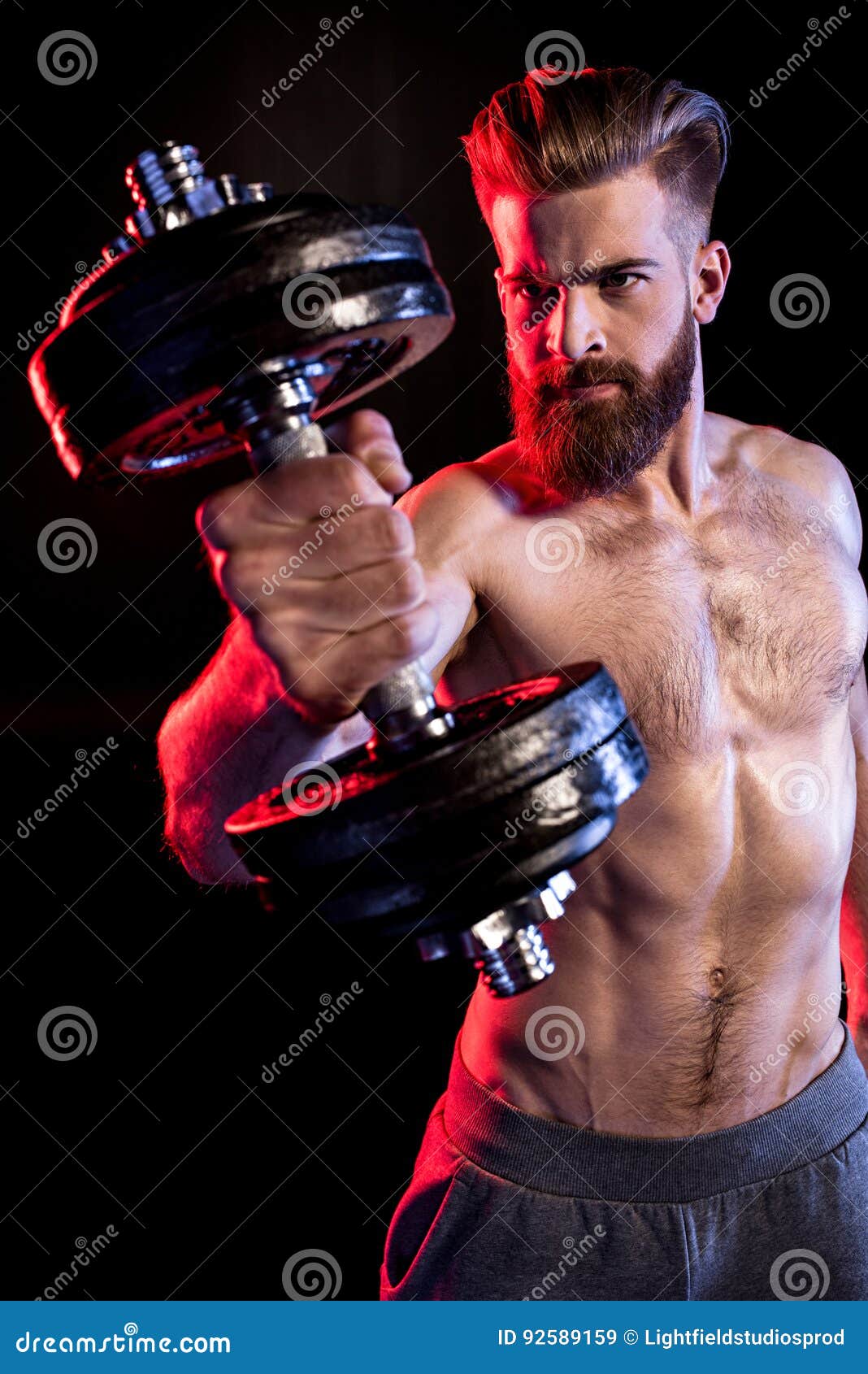 Bodybuilder Training with Dumbbell Isolated on Black with Dramatic ...