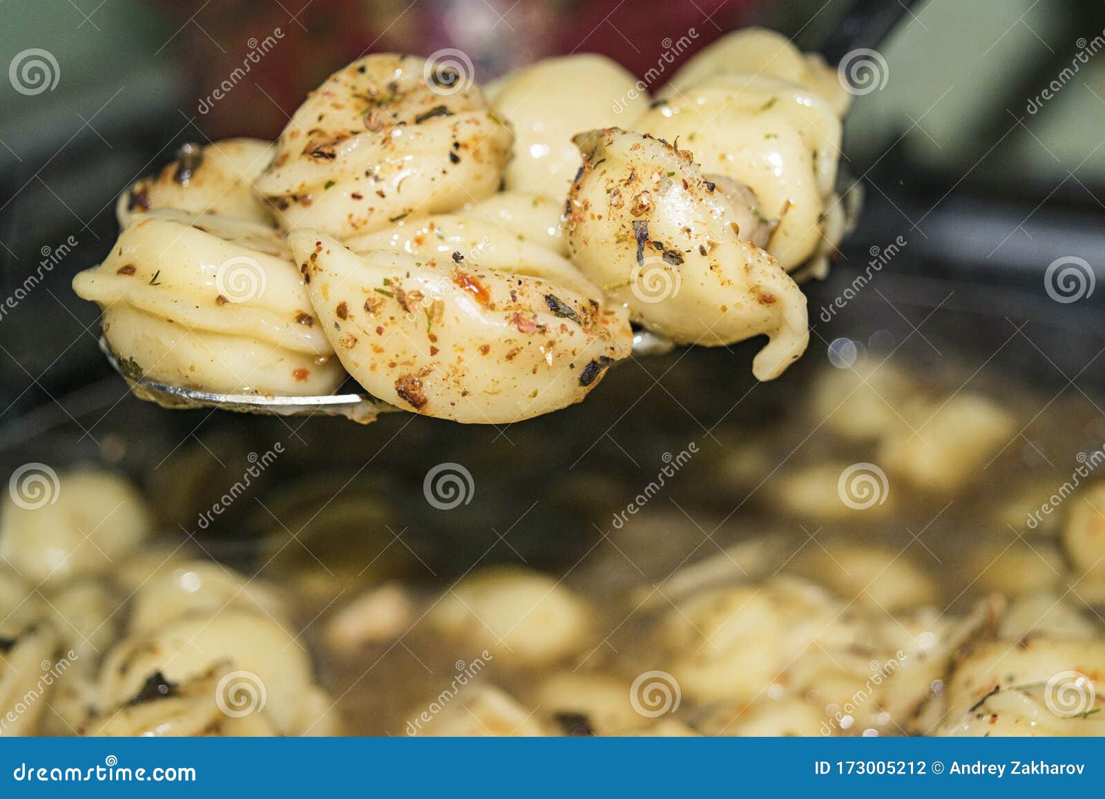 Boiled Dumplings with Spices on a Spoon Over a Pot of Cooked Dumplings ...