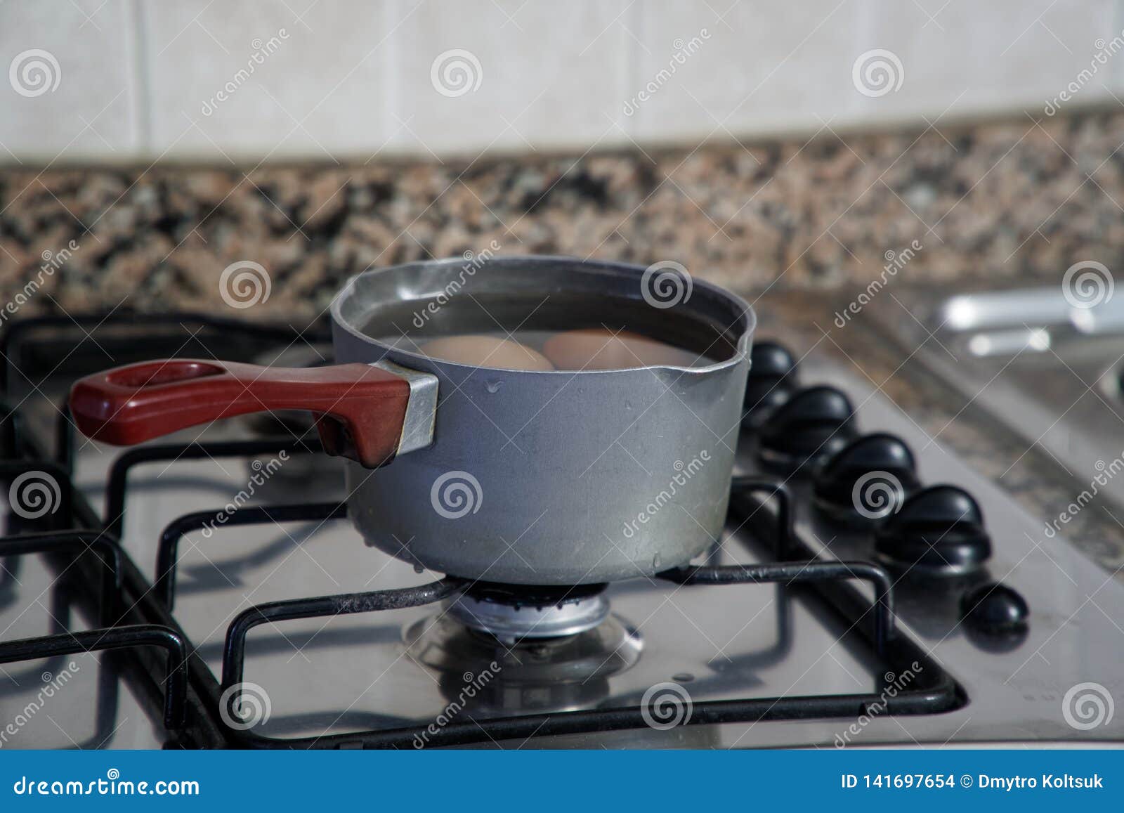 Boiled Eggs in Dipper of Water on the Kitchen Stove Stock Photo - Image ...