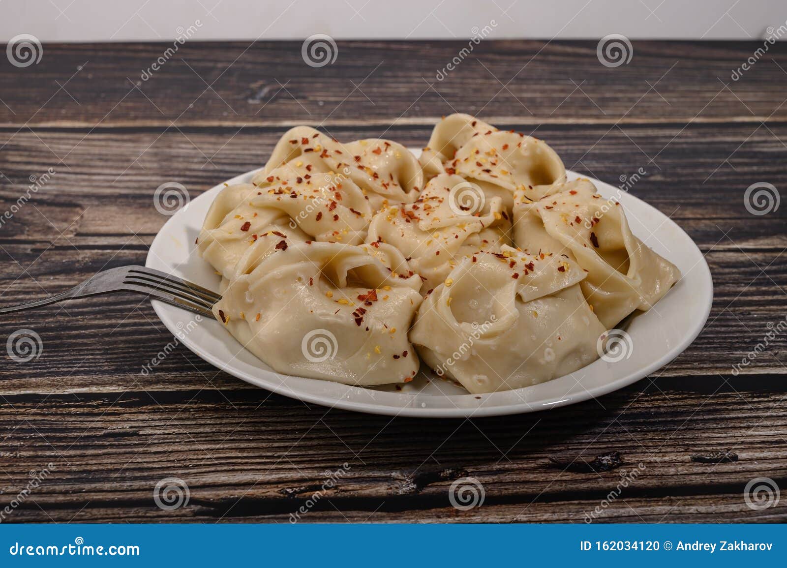 Boiled Manti with Beef on a Plate with Spices on a Wooden Table Stock ...