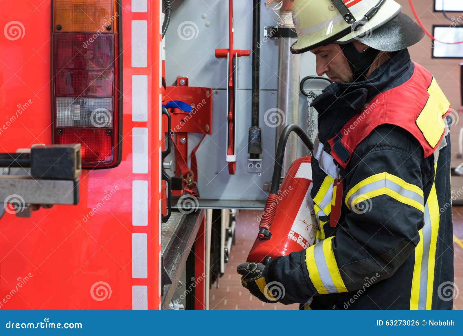 Bombero En El Coche De Bomberos Con Un Extintor Foto de archivo ...