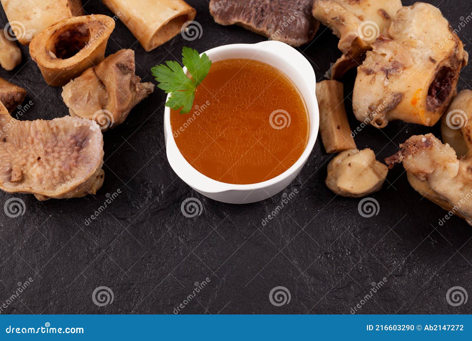 Bone Broth on a Stone Surface Next To Boiled Beef Bones. Selective ...