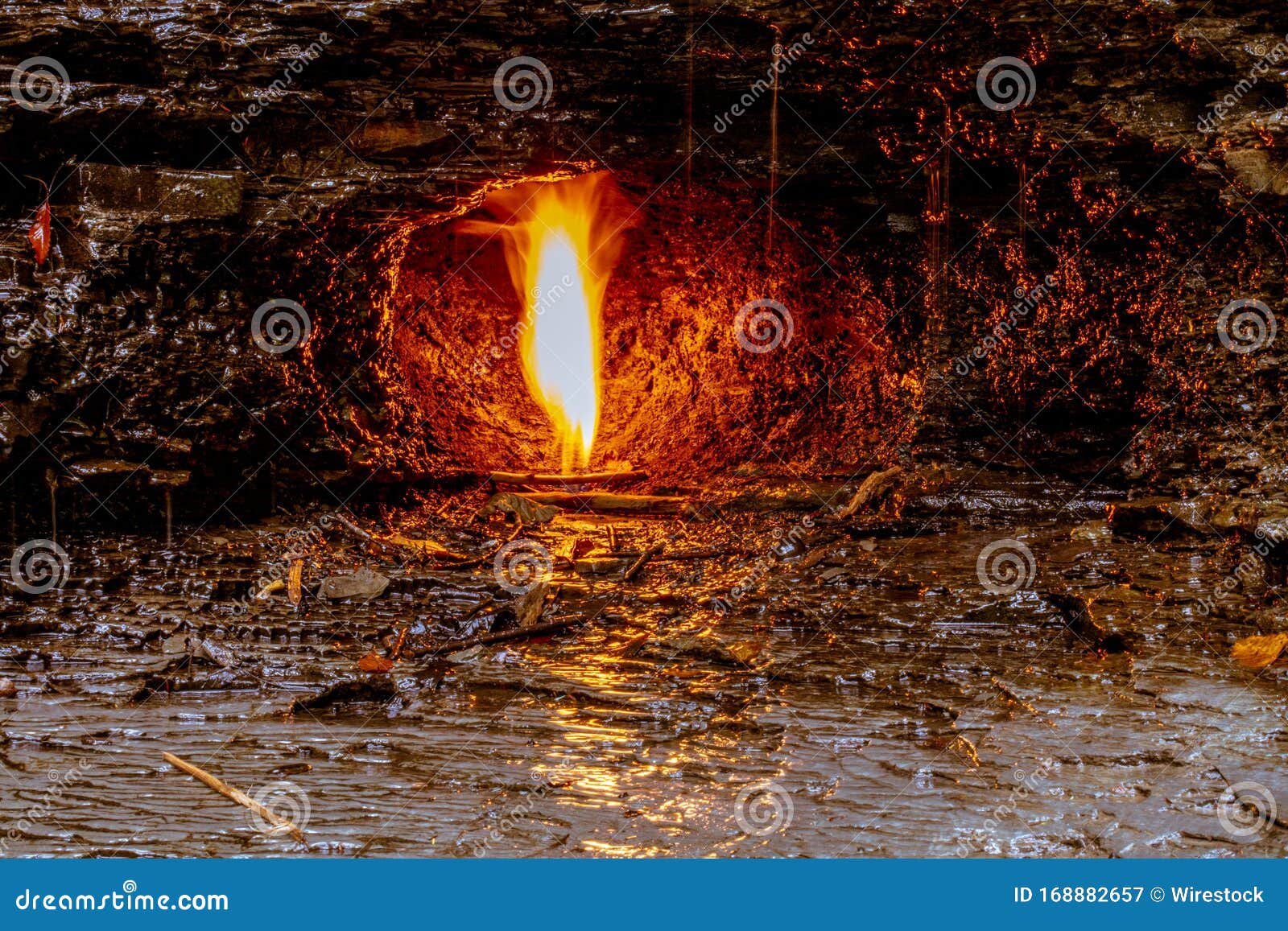 Bonfire in a Cave Surrounded by Rocks and Branches during the Rain ...