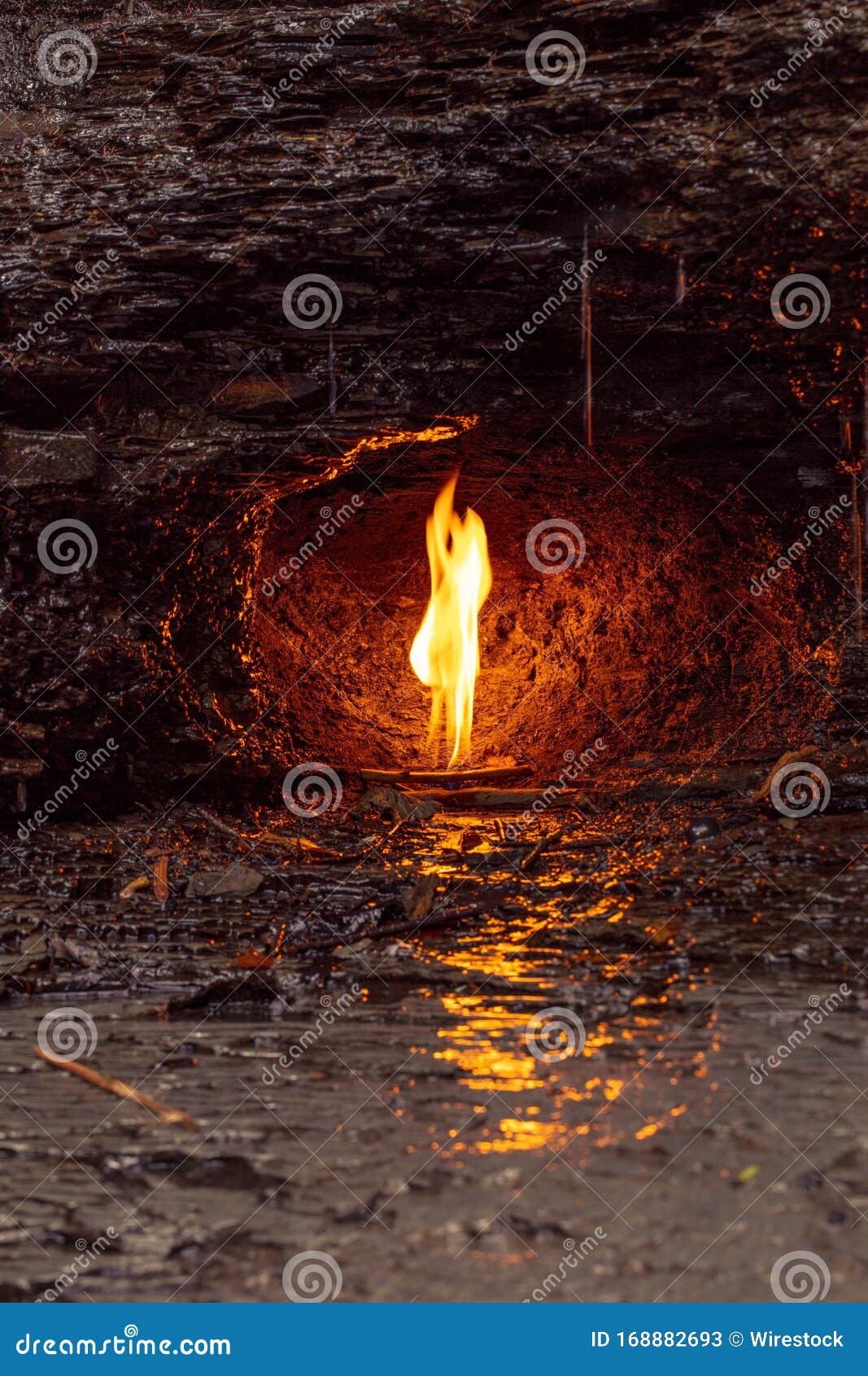 Bonfire in a Cave Surrounded by Rocks and Branches during the Rain ...