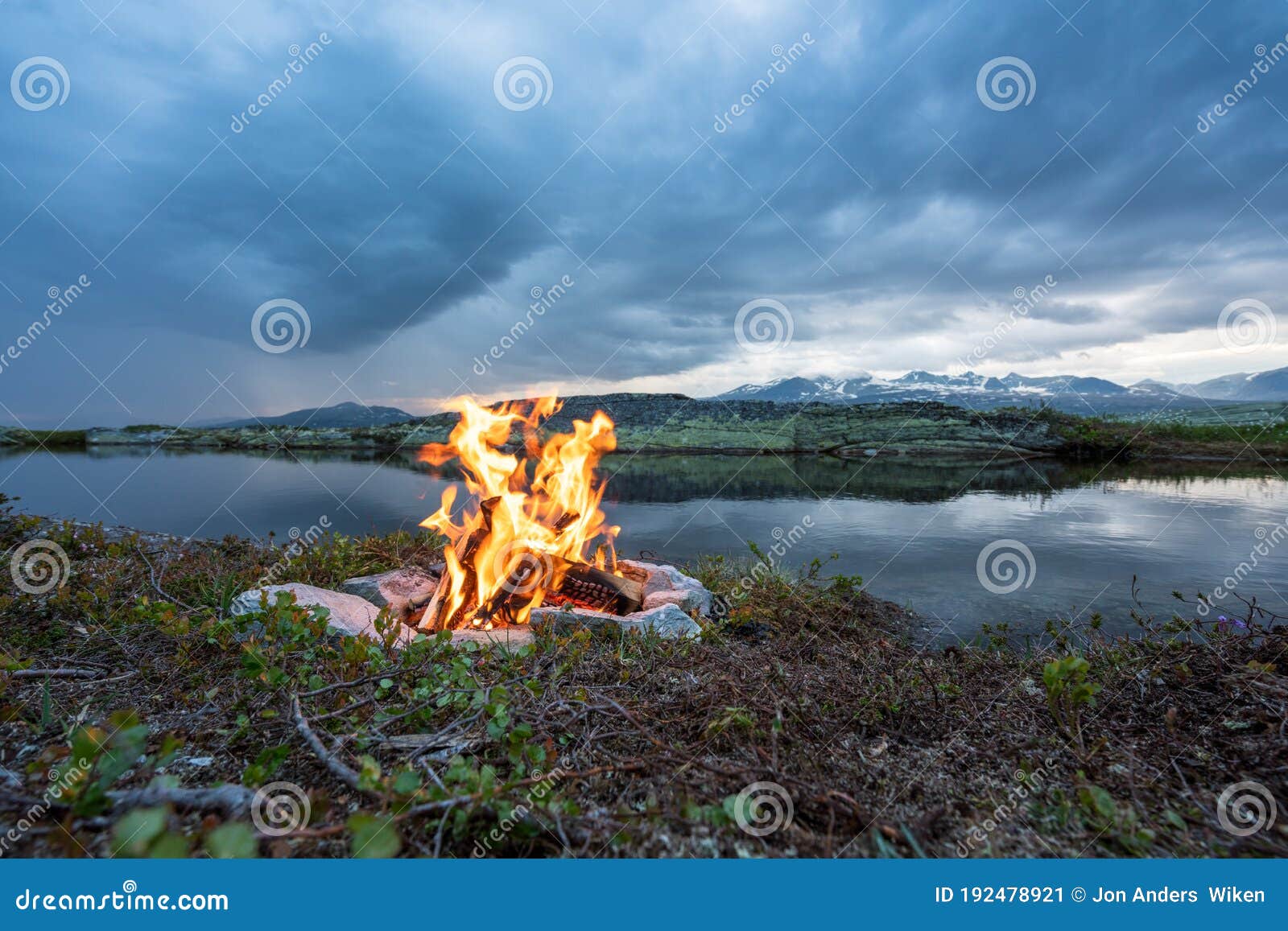 Bonfire Next To Lake at Evening during Blue Hour with Mountain Scenery ...