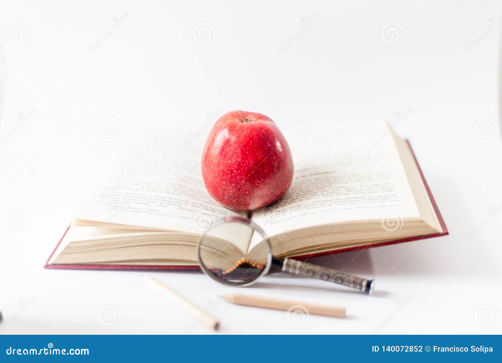 Book, Magnifying Glass and Apple on the Table. Open the Book with the ...