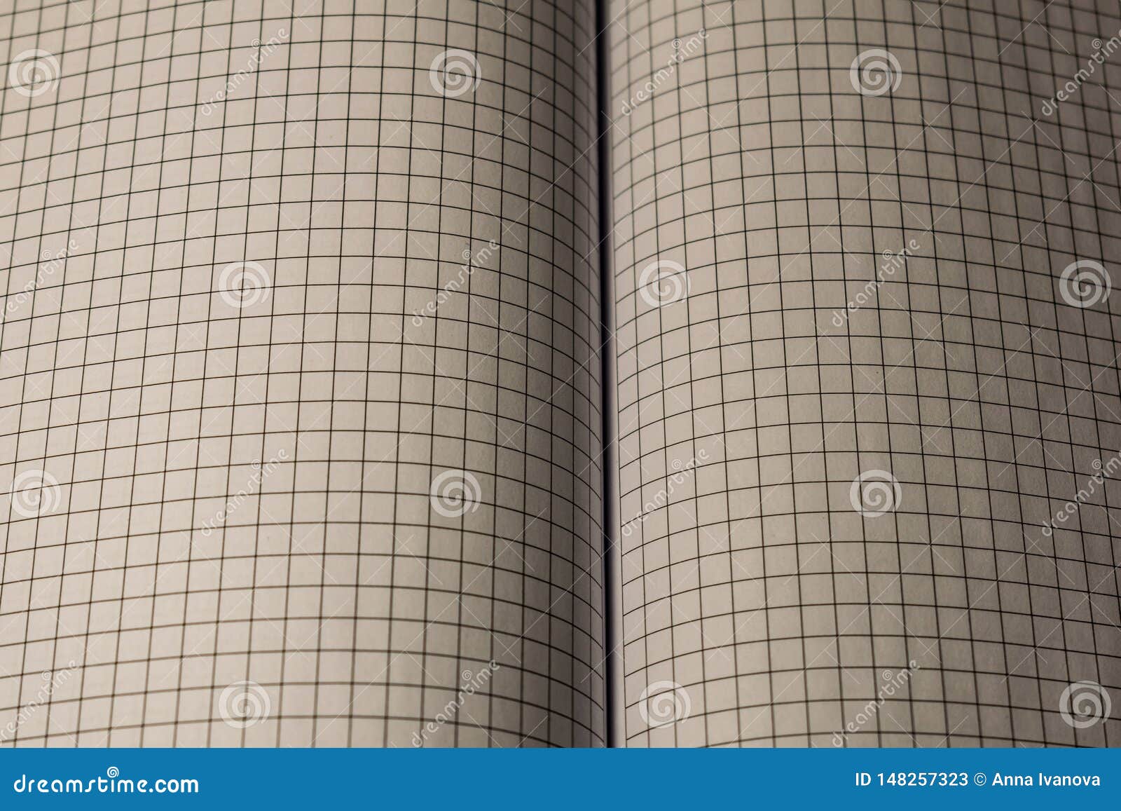 A Book, a Notebook with a Checkered Pattern on a Wooden Table in ...