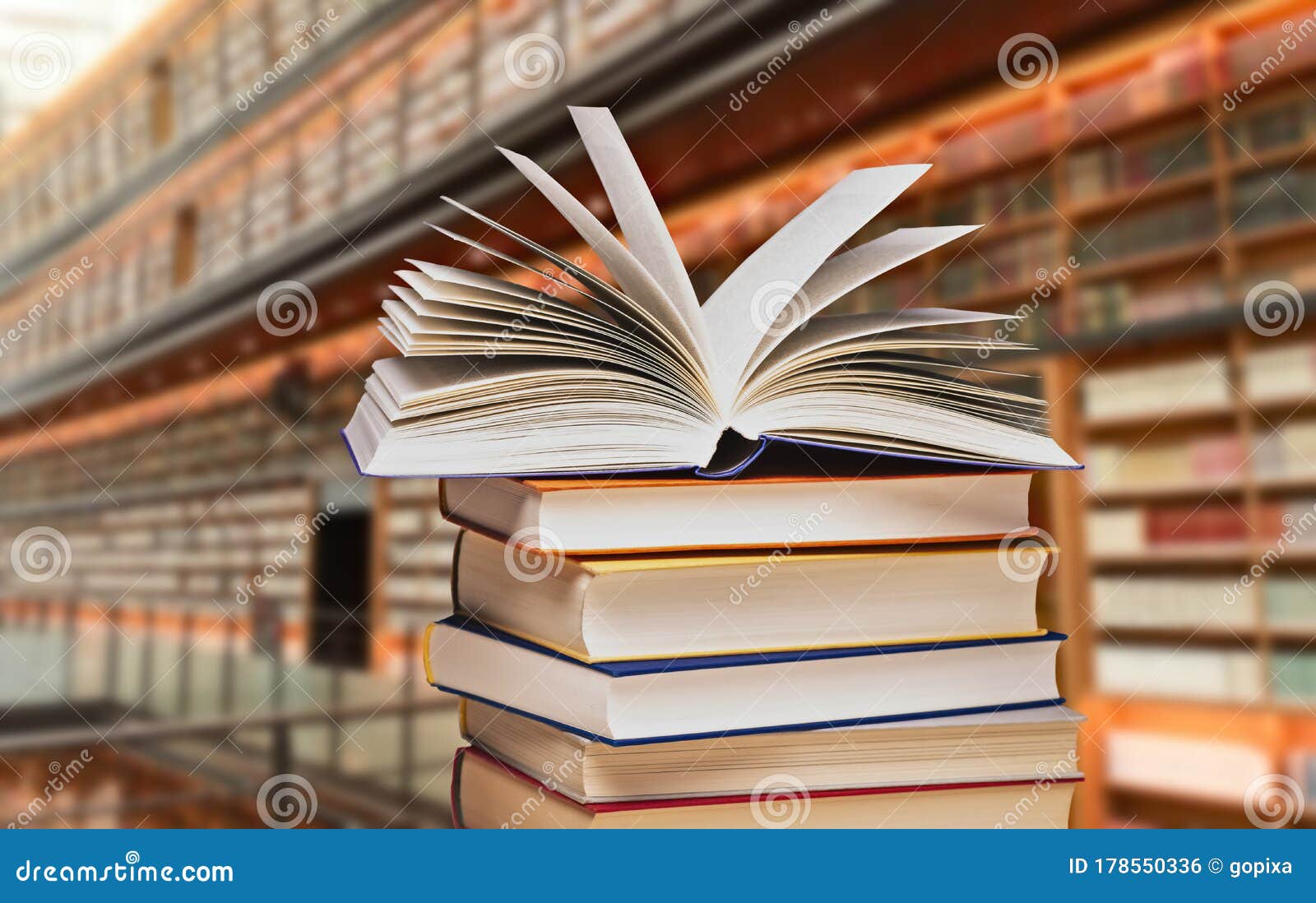 Book Piles in Front of Library Shelves Stock Photo - Image of ...