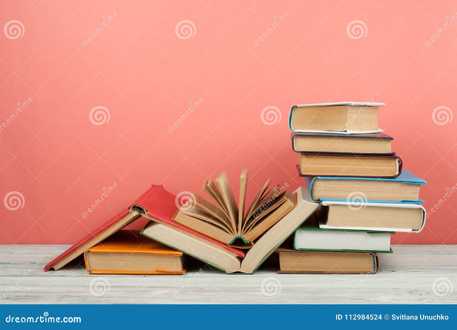 Book Stacking. Open Book, Hardback Books on Wooden Table and Pink ... Book Stacking. Open Book, Hardback Books on Wooden Table and Pink ...