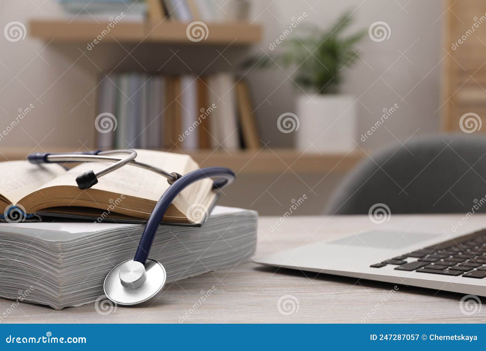 Book, Stethoscope, Laptop and Stack of Documents on Table Indoors ...