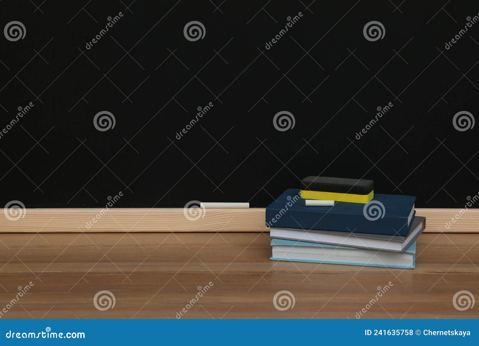 Books, Pieces of Chalk and Duster on Wooden Table Near Blackboard ... Books, Pieces of Chalk and Duster on Wooden Table Near Blackboard ...