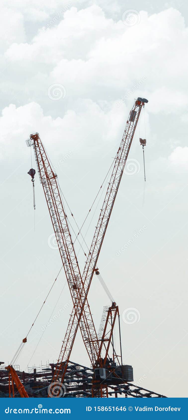 Boom Cranes at a Construction Site Against the Sky and Clouds Stock ...