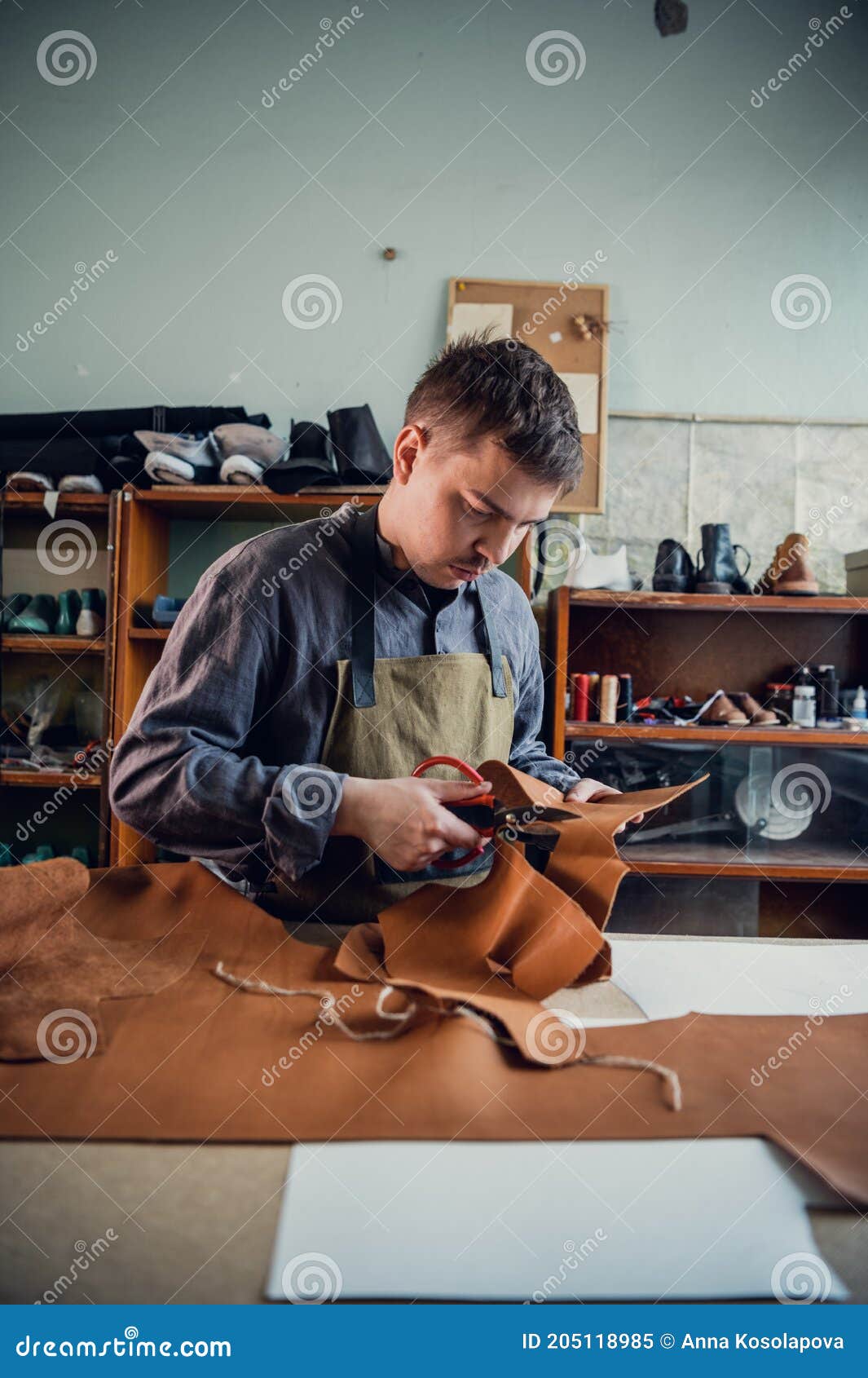 In a Boot Shop, an Experienced Young Master Cuts Out Leather Shoe ...