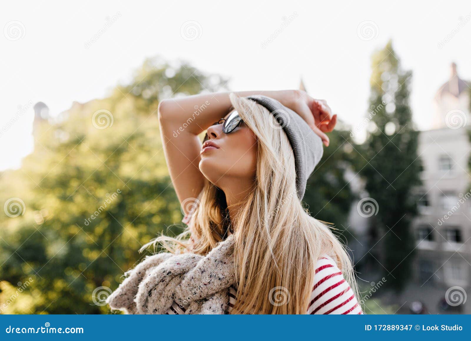 Bored Blonde Girl In Hat And Scarf Looking At Sky While Walking At The
