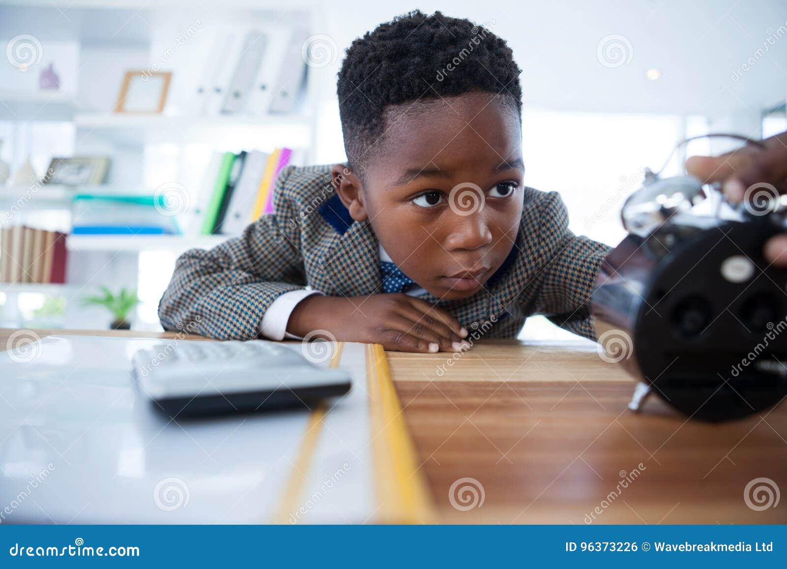 Bored Businessman Checking Alarm Clock while Leaning on Desk Stock ...