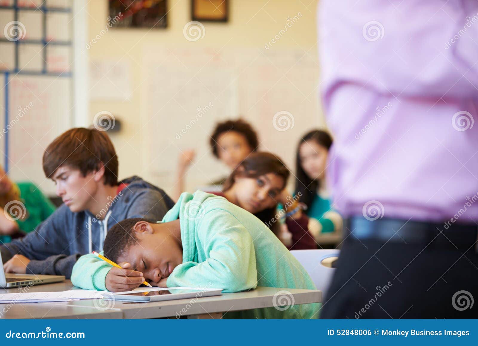 Bored High School Pupil Slumped on Desk in Classroom Stock Photo ...