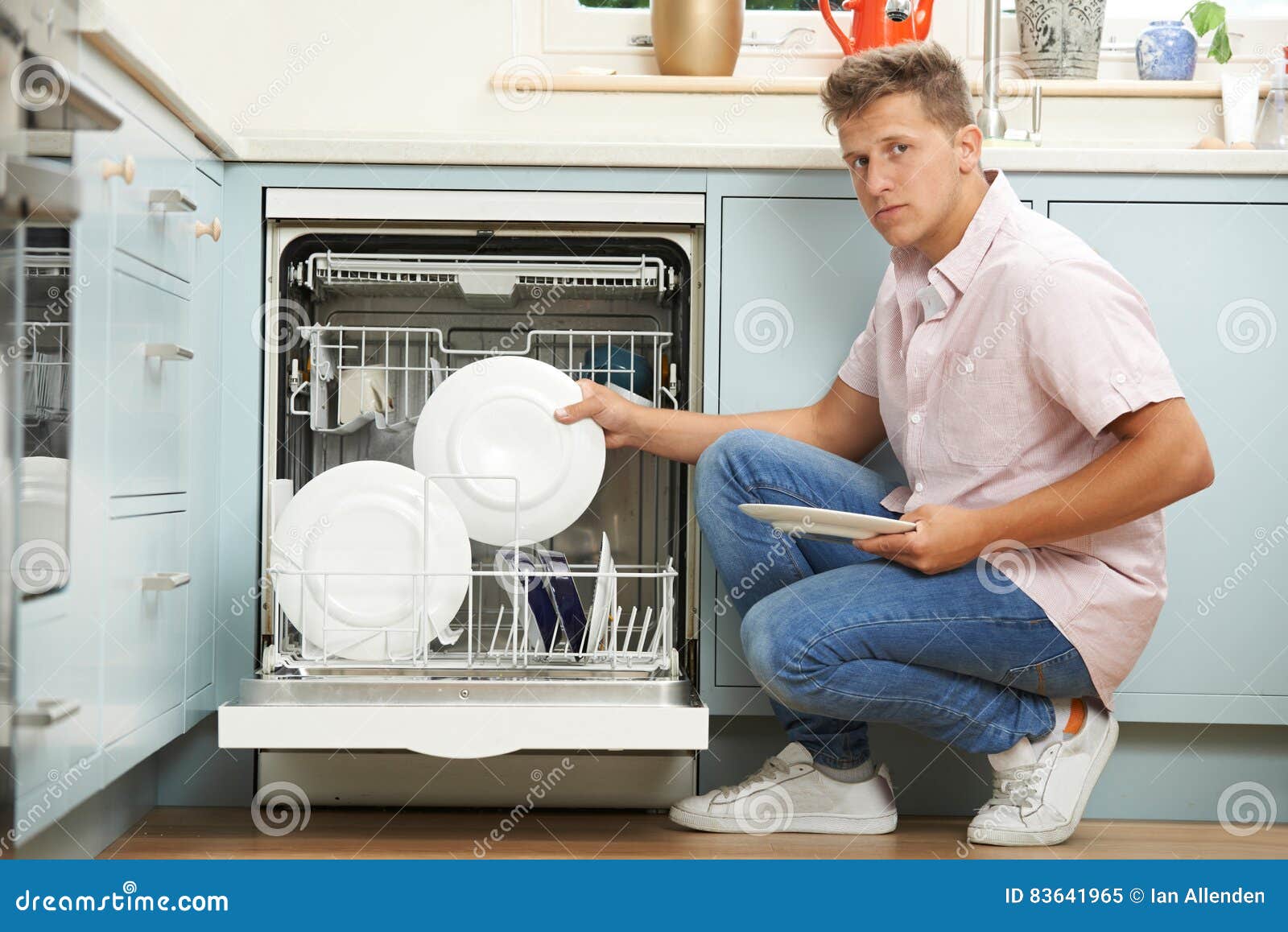 Bored Man Loading Dishwasher in Kitchen Stock Image - Image of plate ...