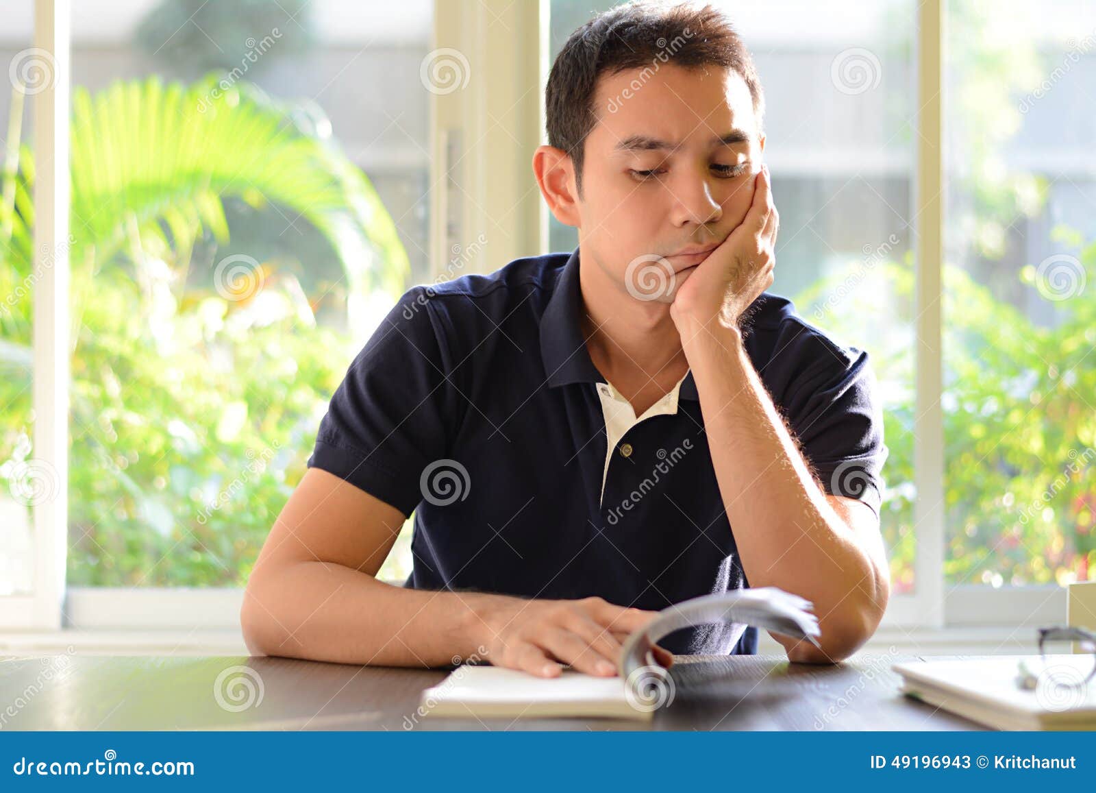 Bored Man Reading Book with Hand on Chin Stock Image - Image of adult ...