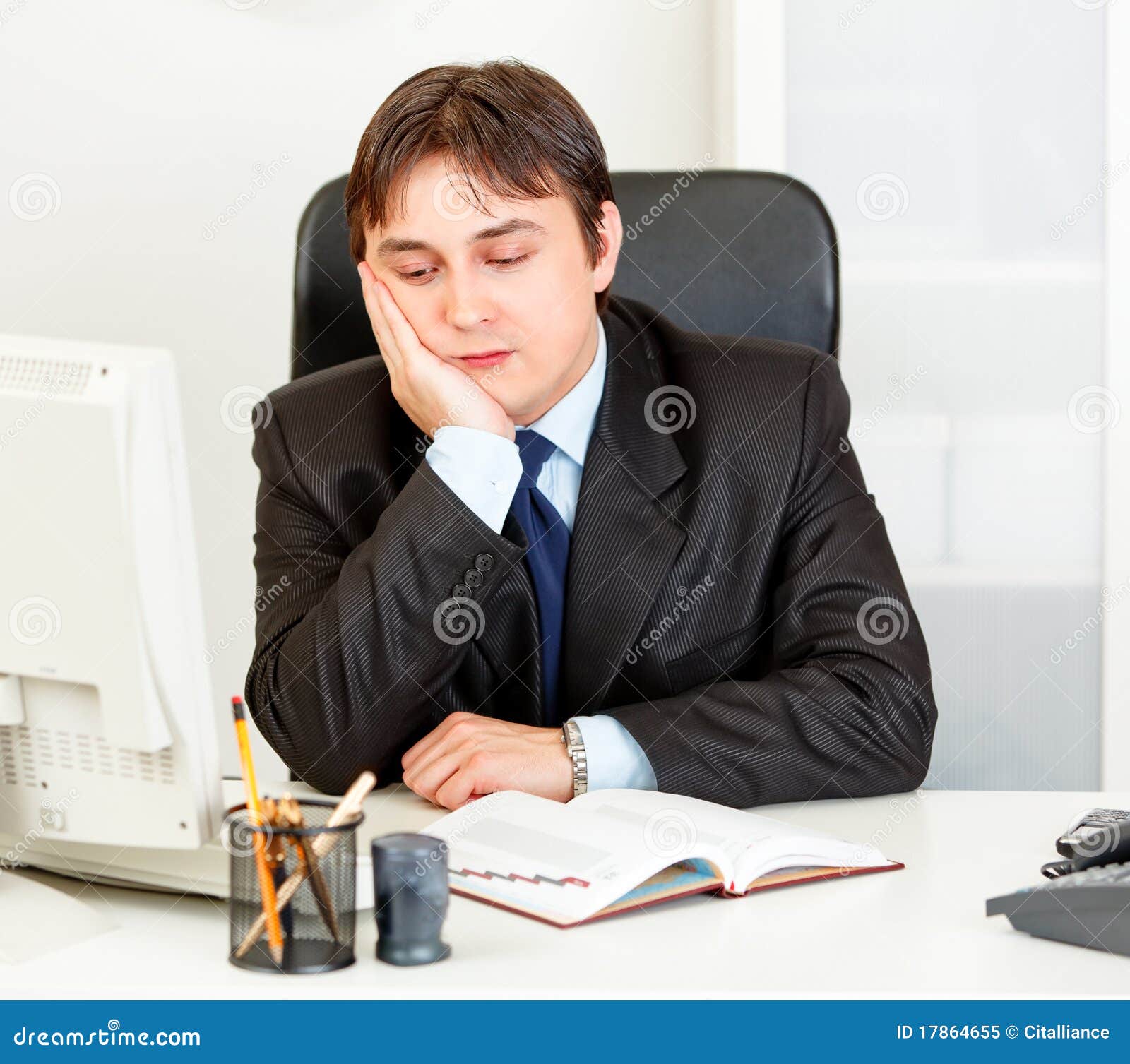 Bored Modern Businessman Sitting at Desk in Office Stock Image - Image ...