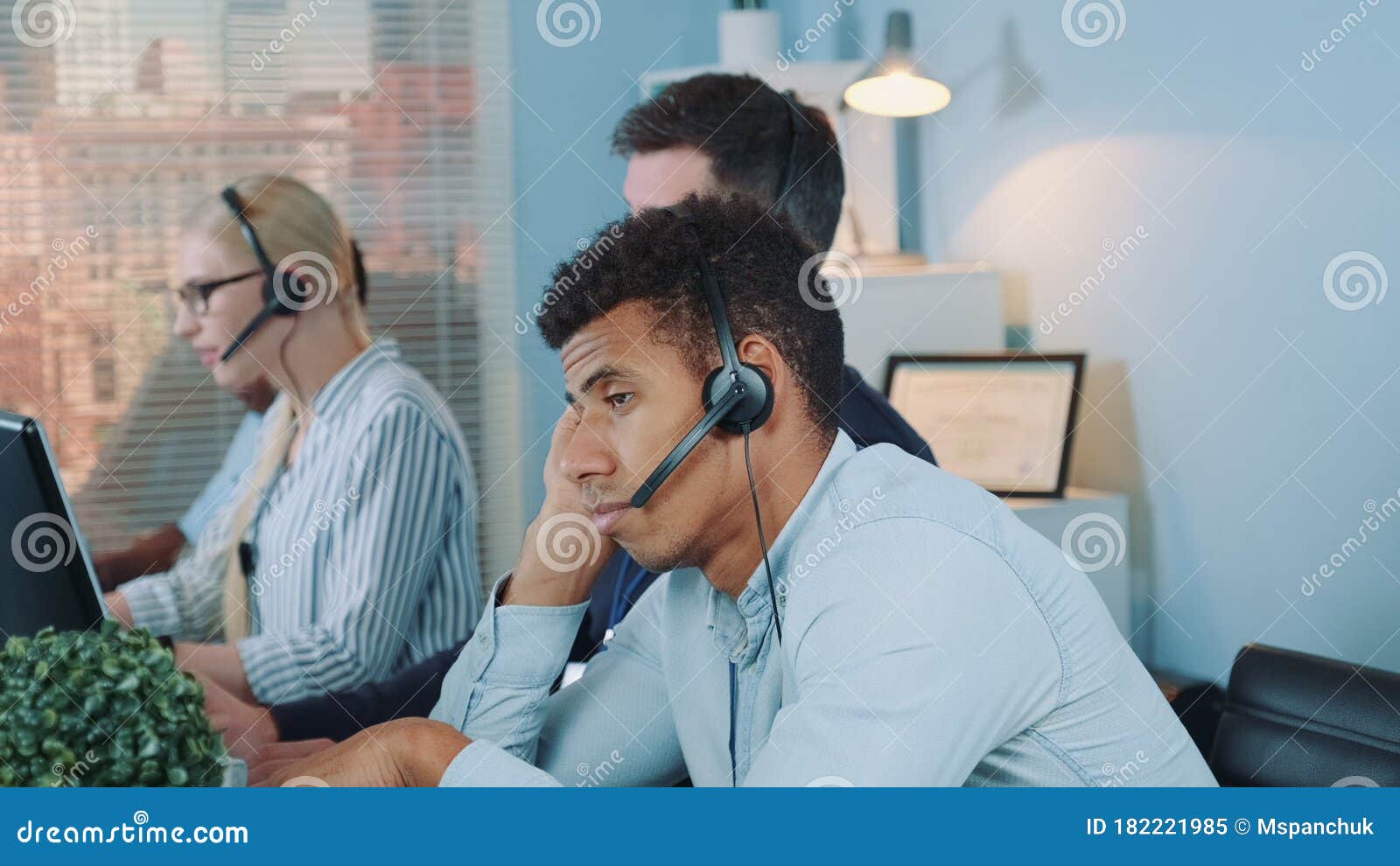 Bored Multiethnic Customer Support Operator Waiting for Telephone Call ...