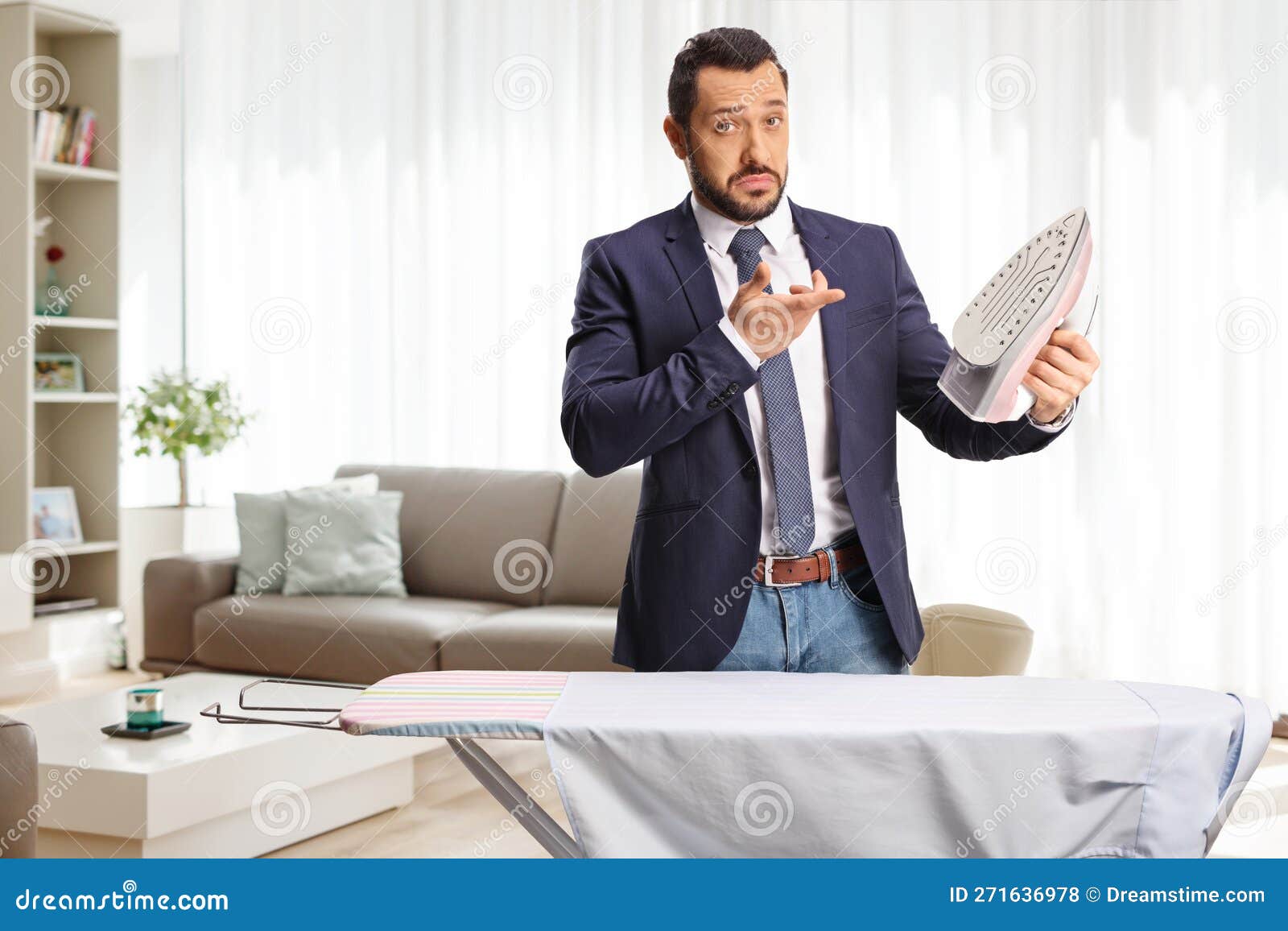 Bored Professional Man Holding an Iron Behind an Ironing Board Stock ...