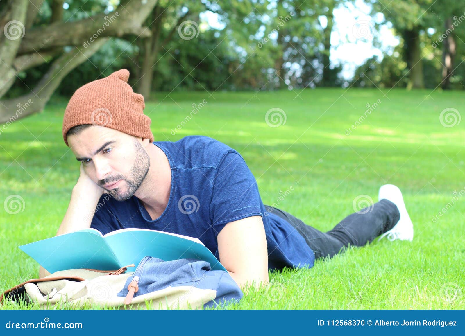 Bored Student Reading His Notebook on Campus Stock Photo - Image of ...