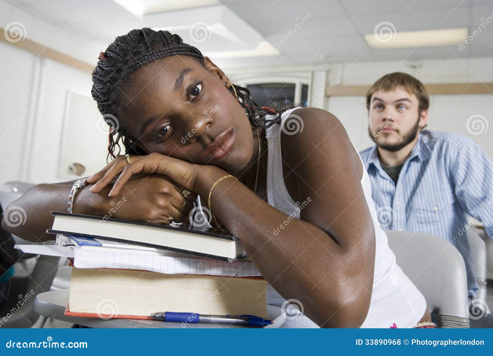 Bored Student Resting on Stack of Books in Classroom Stock Photo ...