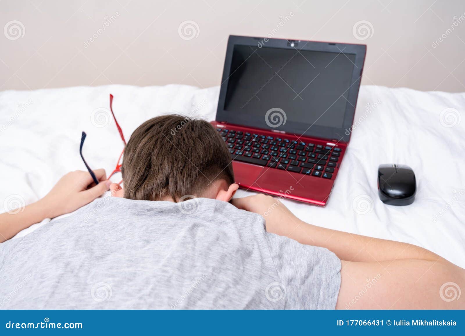 Bored and Tired Boy Lying on a Bed with a Laptop after Doing His ...