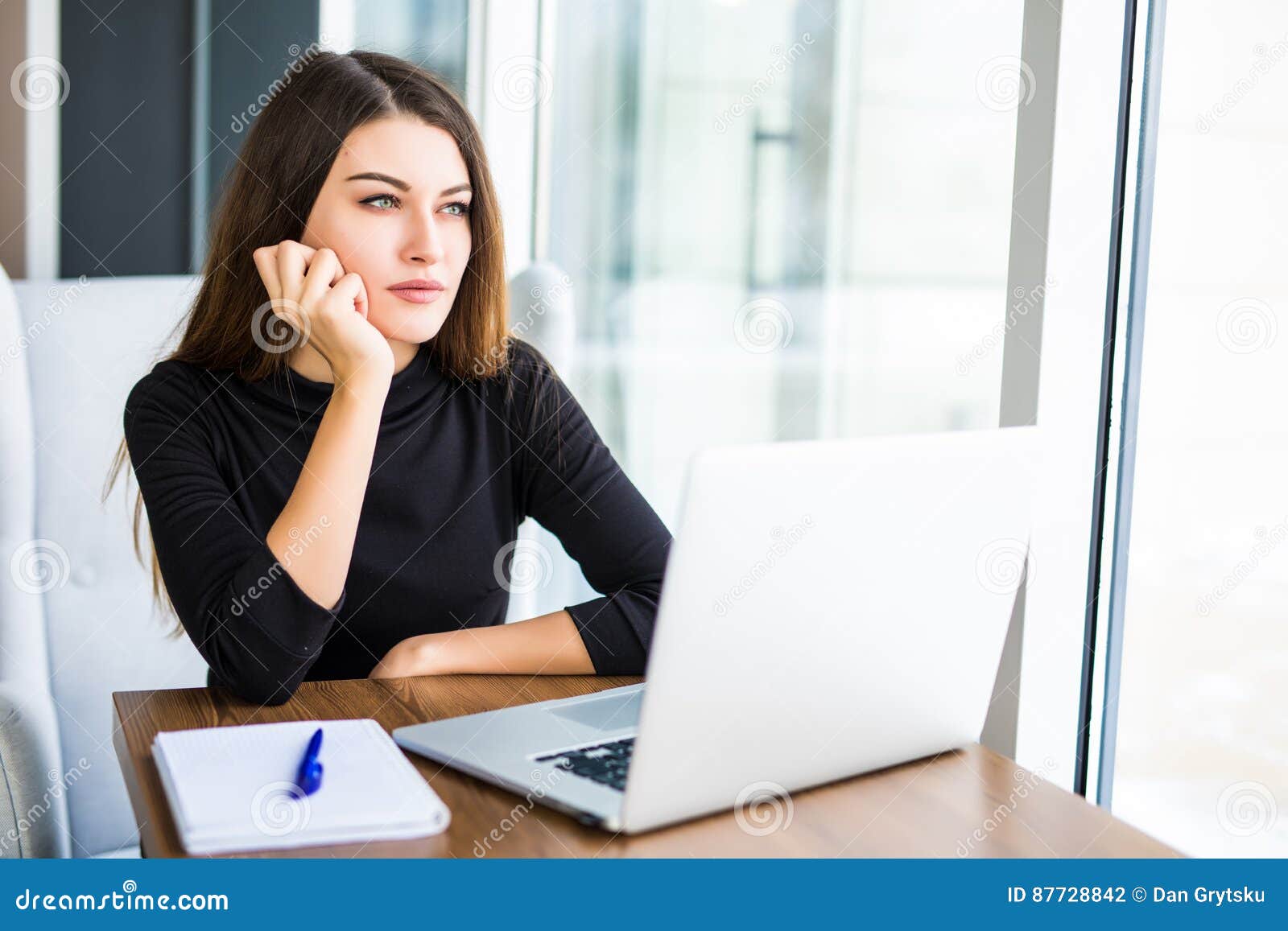 Bored Young Woman in the Office Working with a Laptop Stock Photo ...