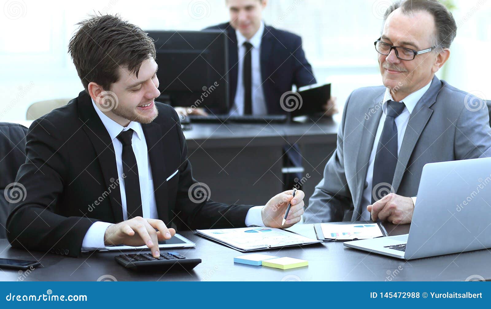 Boss and Employee Discussing the Document Sitting at the Desk in the ...
