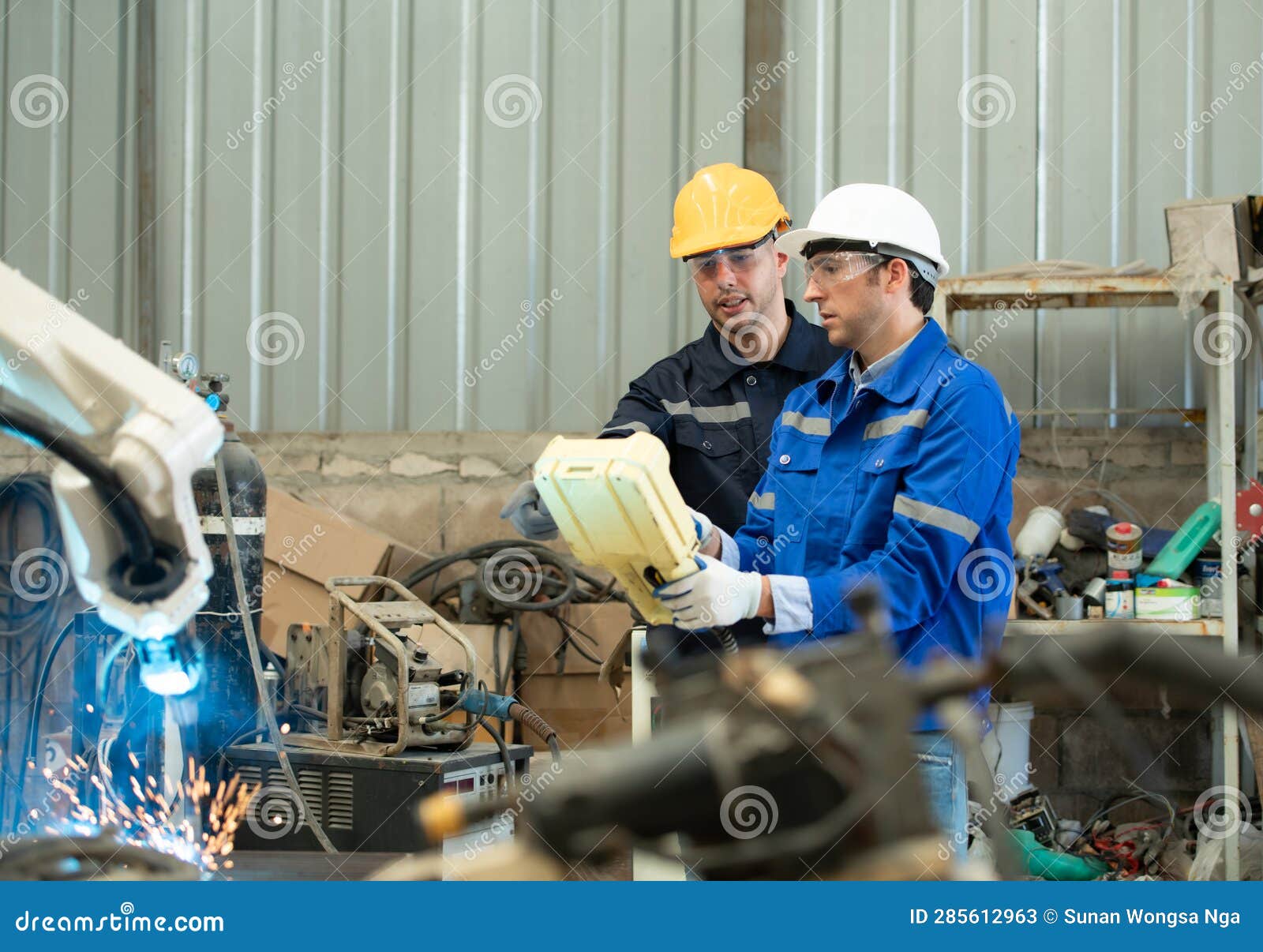 Both of Engineers are Manipulating a Welding Robot Hand. by Combining ...