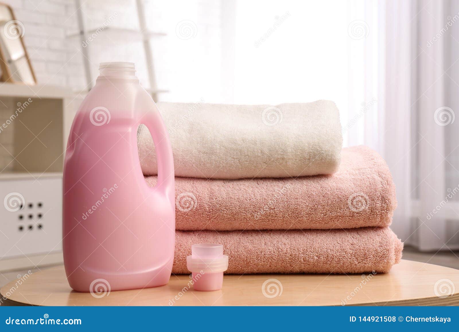 Bottle of Detergent and Clean Towels on Table. Laundry Day Stock Photo ...