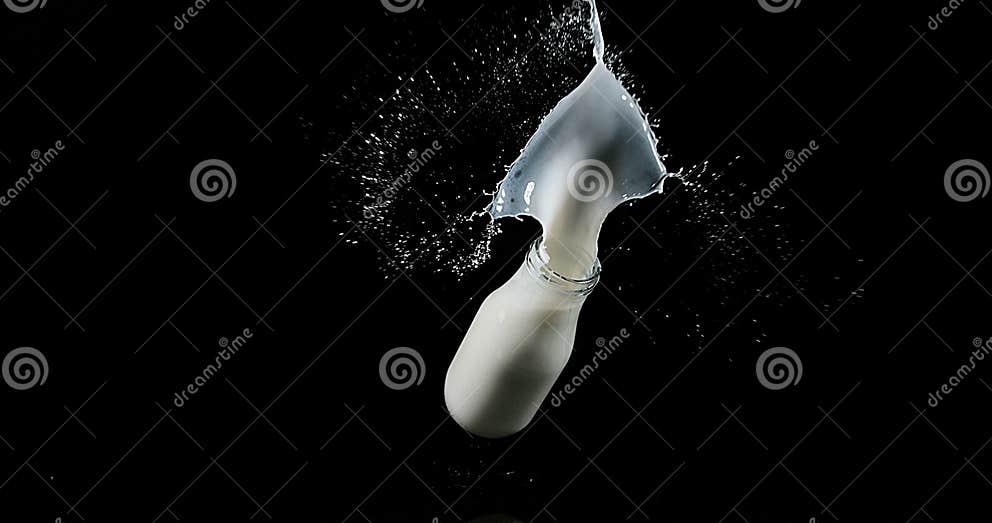 Bottle of Milk Falling and Exploging Against Black Background Stock ...