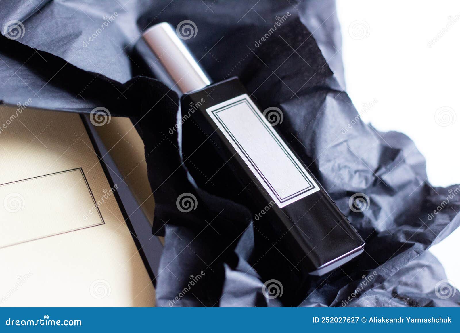 A Bottle of Perfume from a Yellow Box on a White Background Stock Image ...