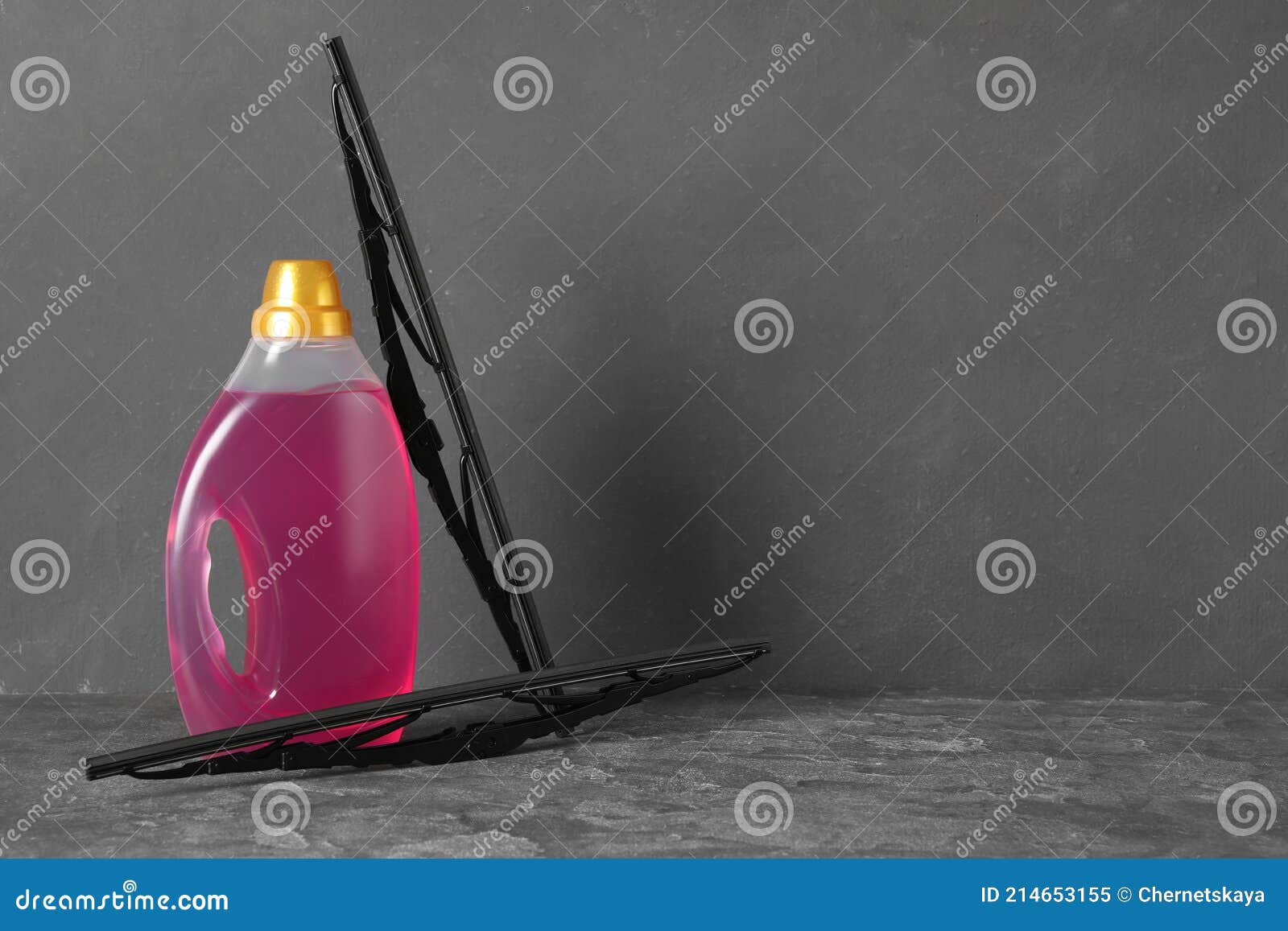Bottle of Windshield Washer Fluid and Wipers on Grey Table. Space for ...