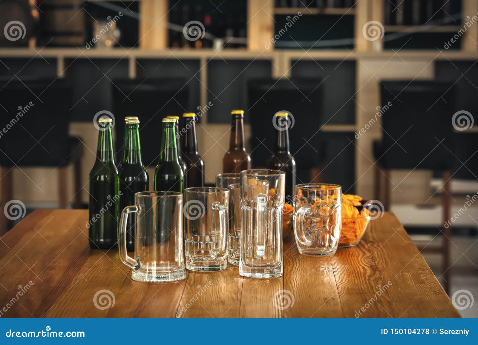 Bottles of Beer with Glasses and Snack on Table in Bar Stock Photo ...