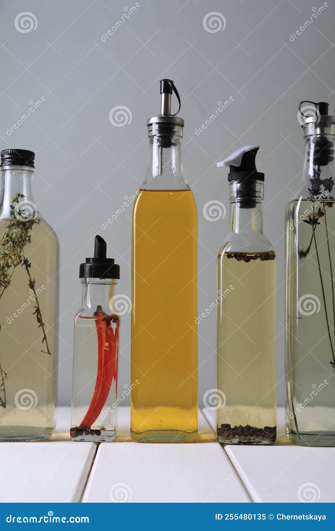 Bottles of Different Cooking Oils on White Wooden Table Against Grey ...