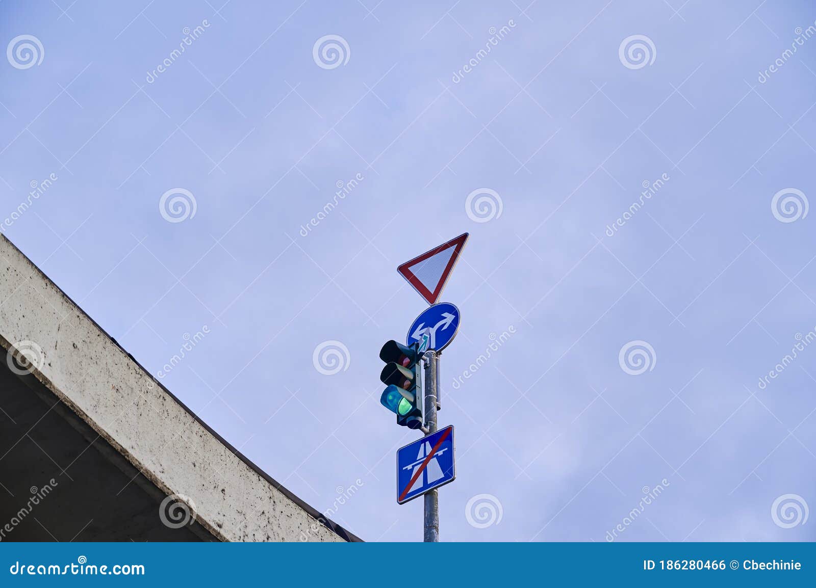 Bottom View Of A Green Traffic Light And Various Traffic Signs At An ...