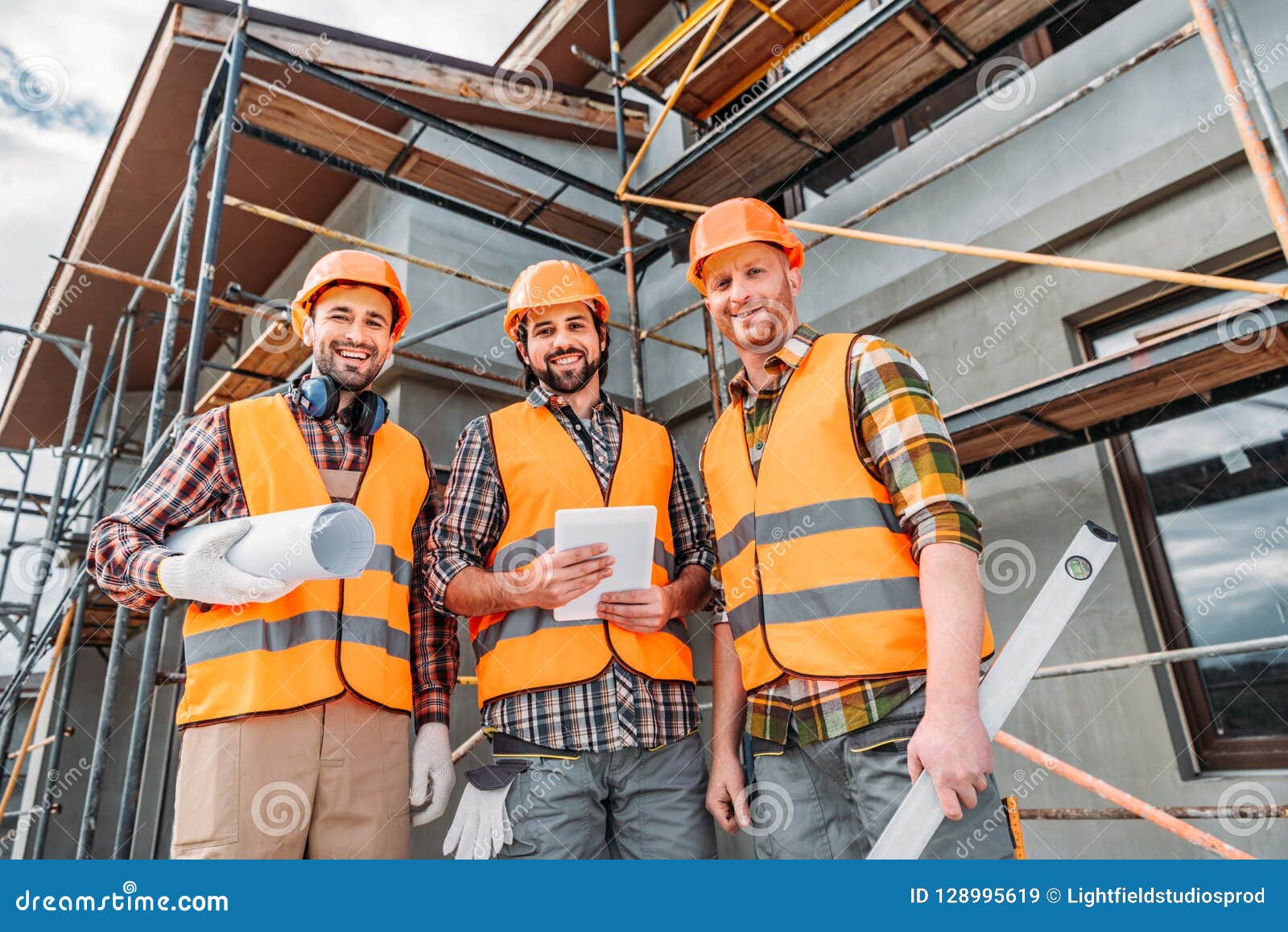 Bottom View of Group of Smiling Builders with Blueprint and Tablet ...