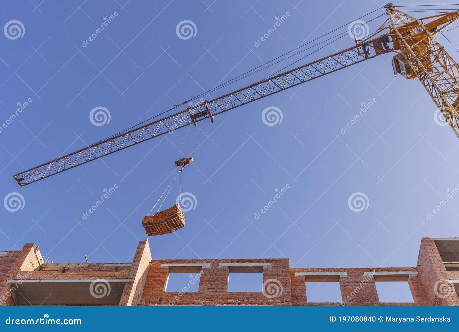 Bottom View of a Tall Tower Crane Near a Brick Building Stock Photo ...