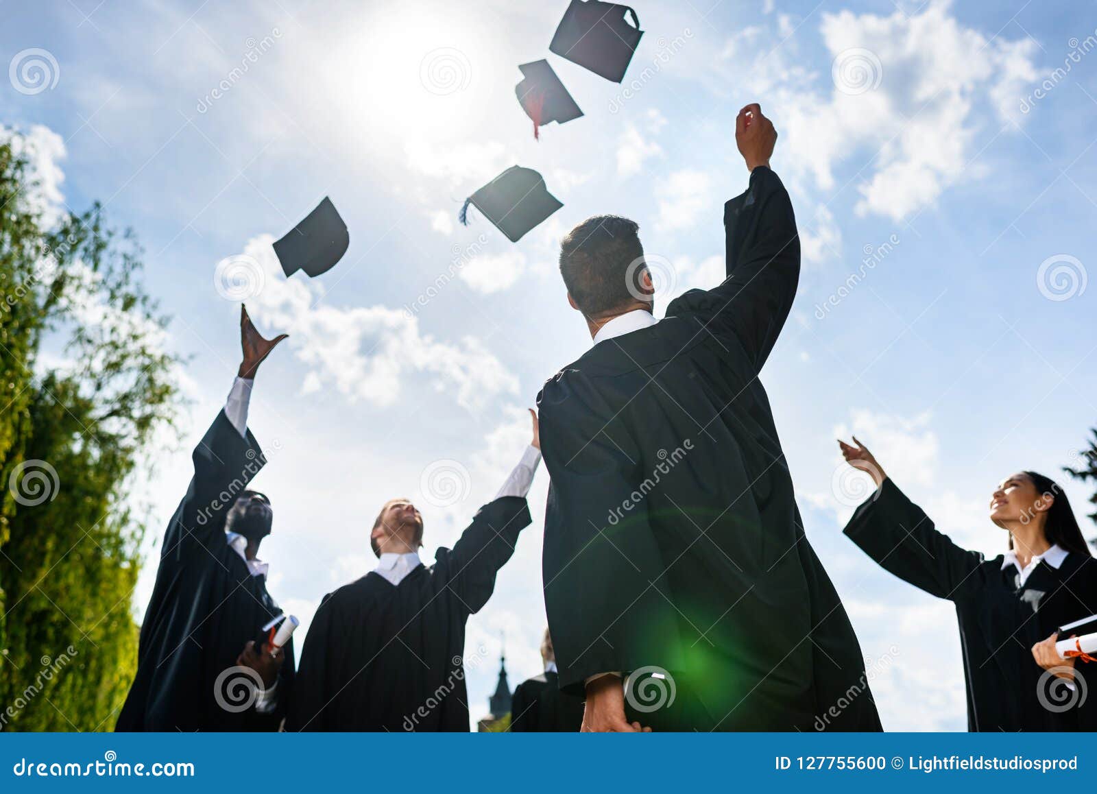 Bottom View of Young Graduated Students Throwing Up Hats in Front of ...