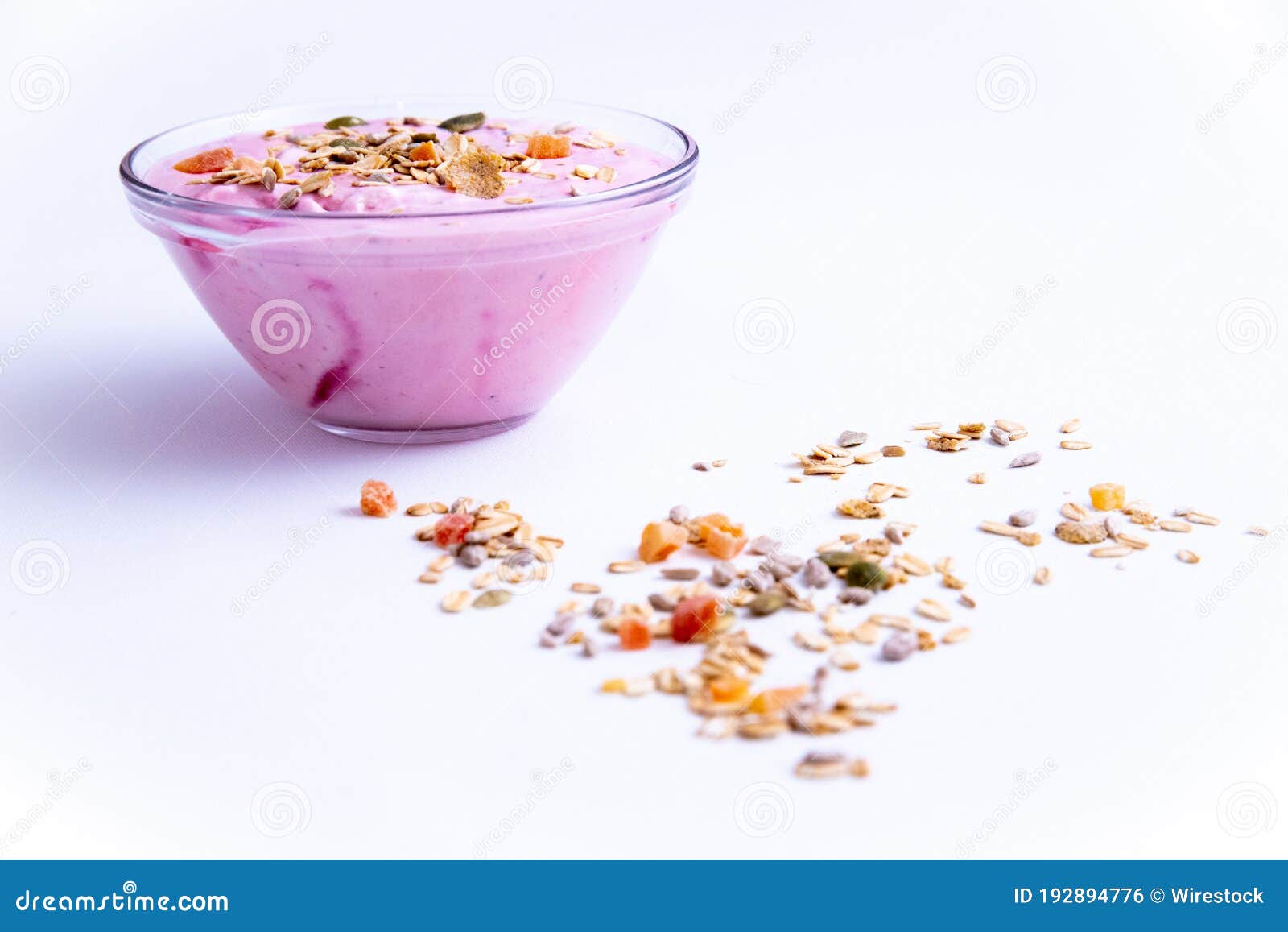 Bowl of Berry Yogurt with Grains and Fruit Chunks on it on a White ...