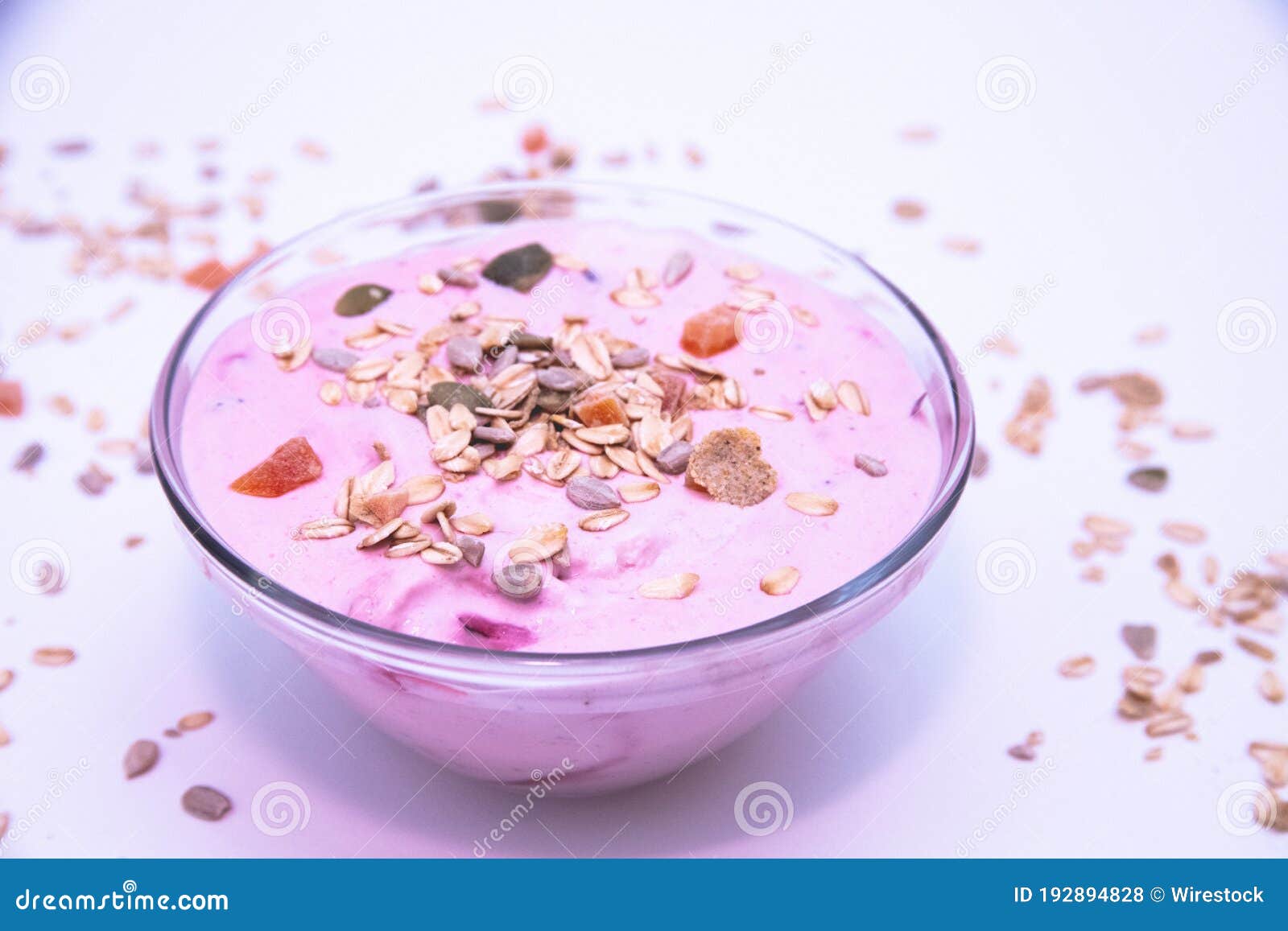 Bowl of Berry Yogurt with Grains and Fruit Chunks on it on a White ...
