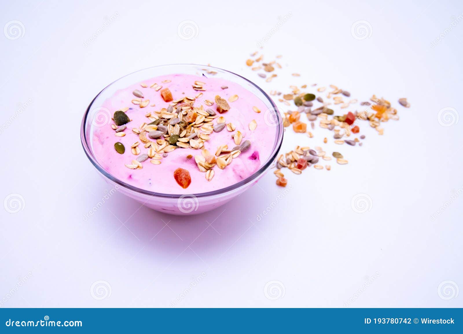 Bowl of Berry Yogurt with Grains and Fruit Chunks on it on a White ...