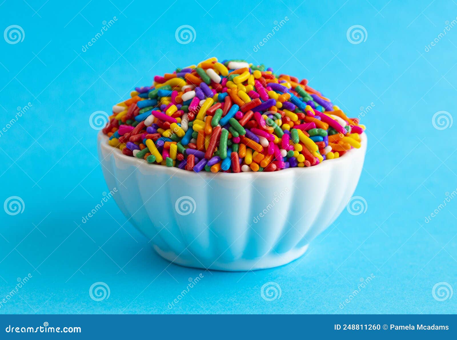Bowl of Bright Rainbow Sprinkles on a Blue Background Stock Photo ...