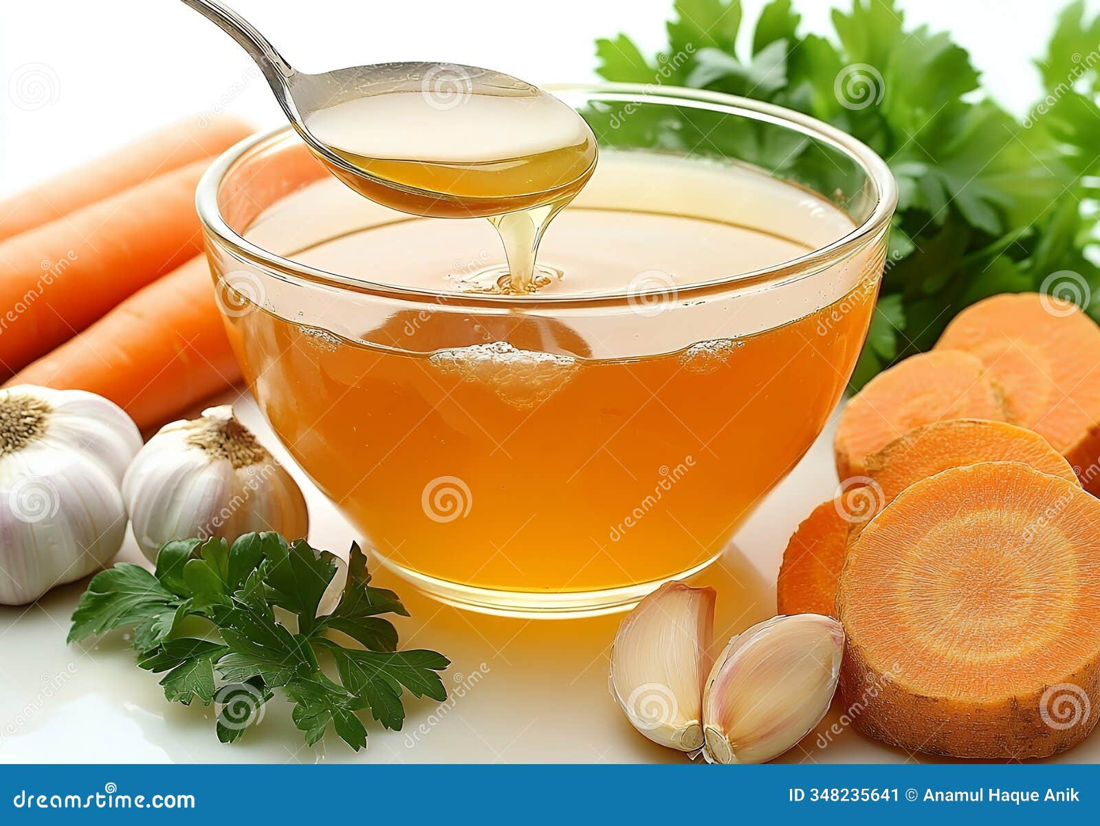 A Bowl of Carrot and Garlic Broth with a Spoon Dripping Broth into the ...