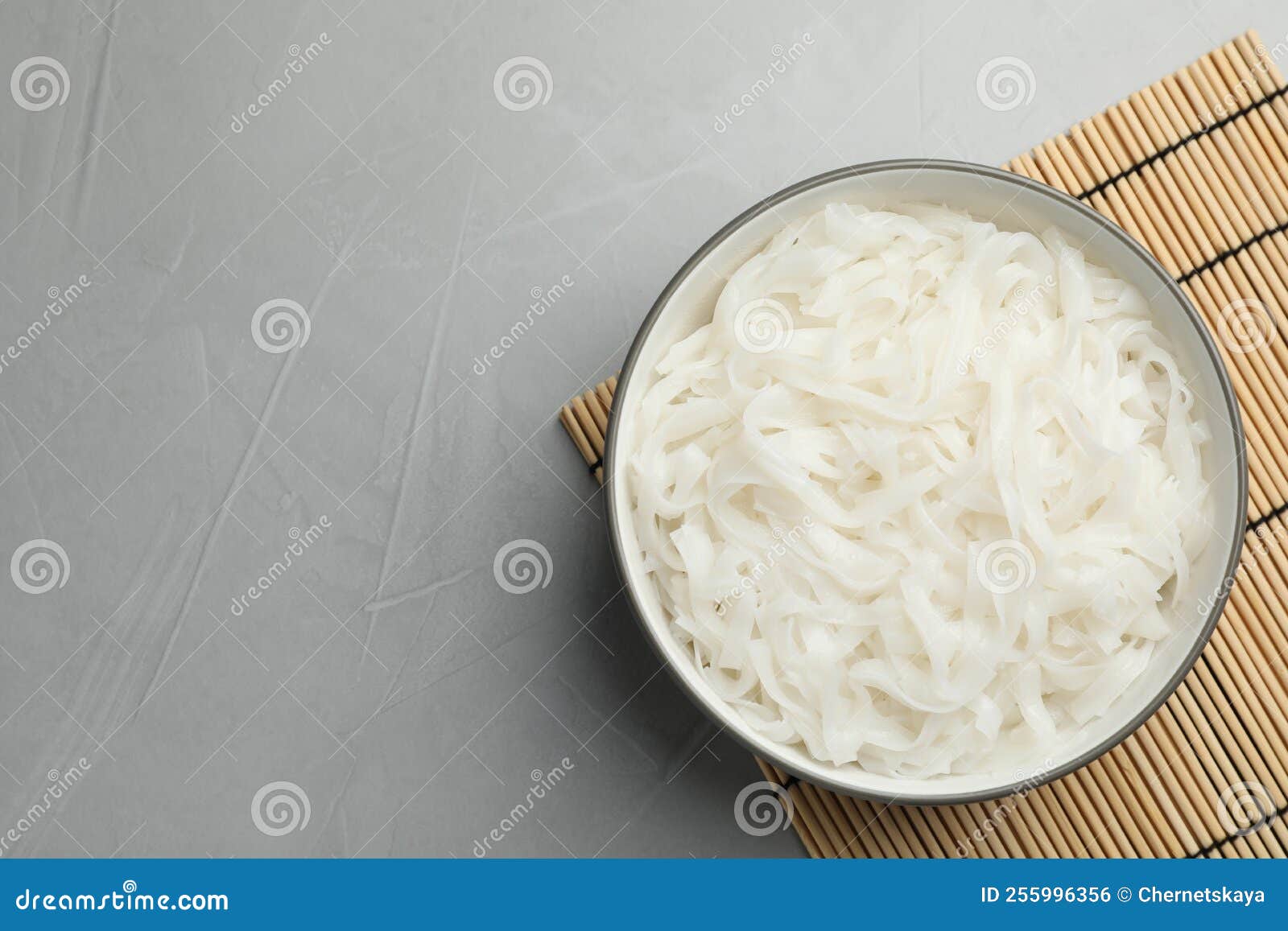 Bowl with Cooked Rice Noodles and Straw Mat on Light Grey Table, Top ...