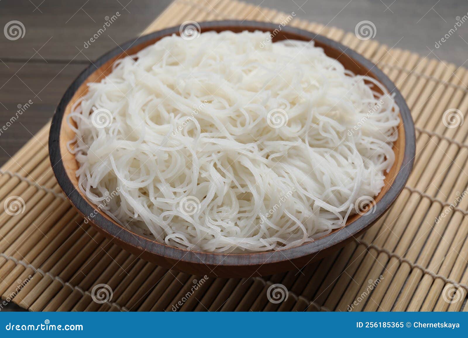 Bowl with Cooked Rice Noodles and Straw Mat on Table, Closeup Stock ...