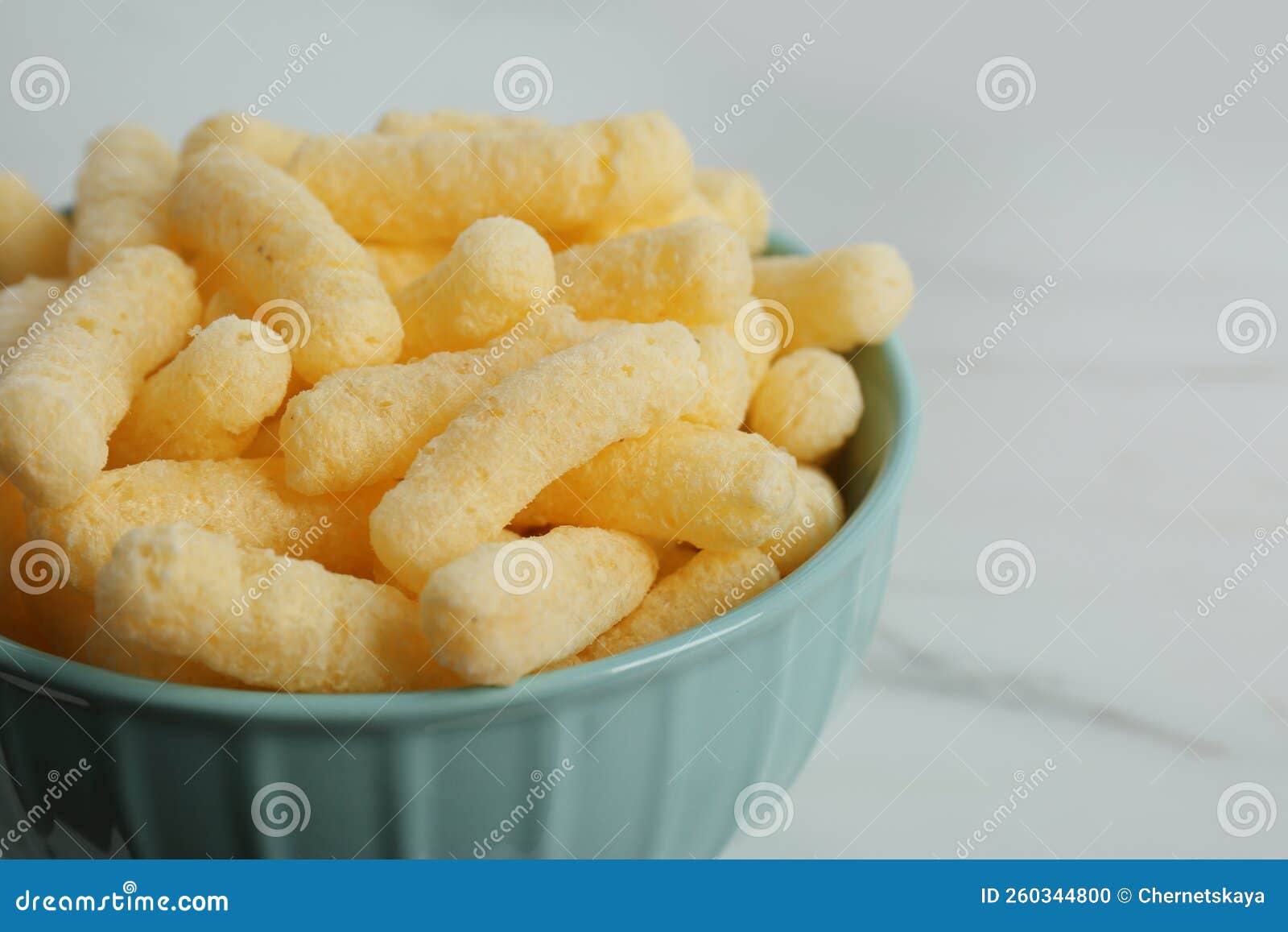 Bowl of Delicious Crispy Corn Sticks on White Marble Table, Closeup ...