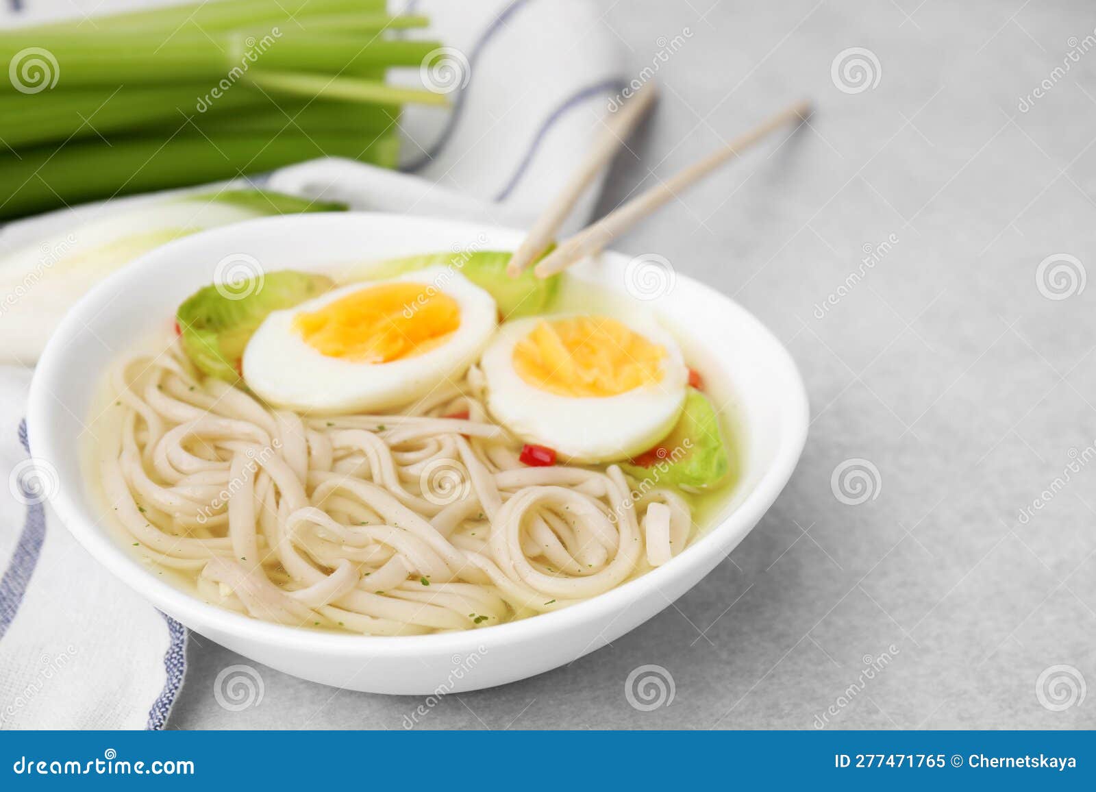Bowl of Delicious Rice Noodle Soup with Celery and Egg on Light Grey ...